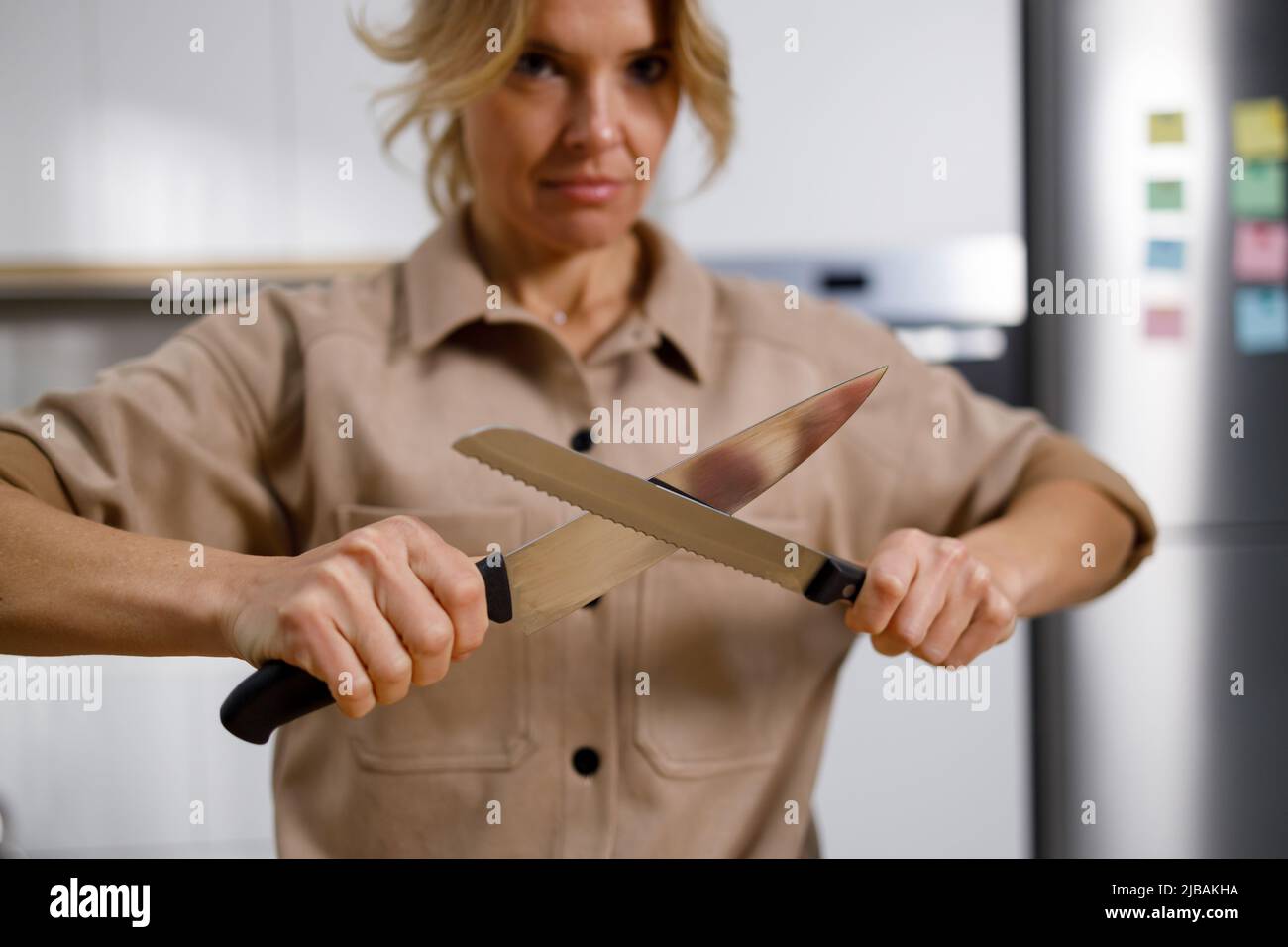 Woman with two knives in the kitchen Stock Photo - Alamy