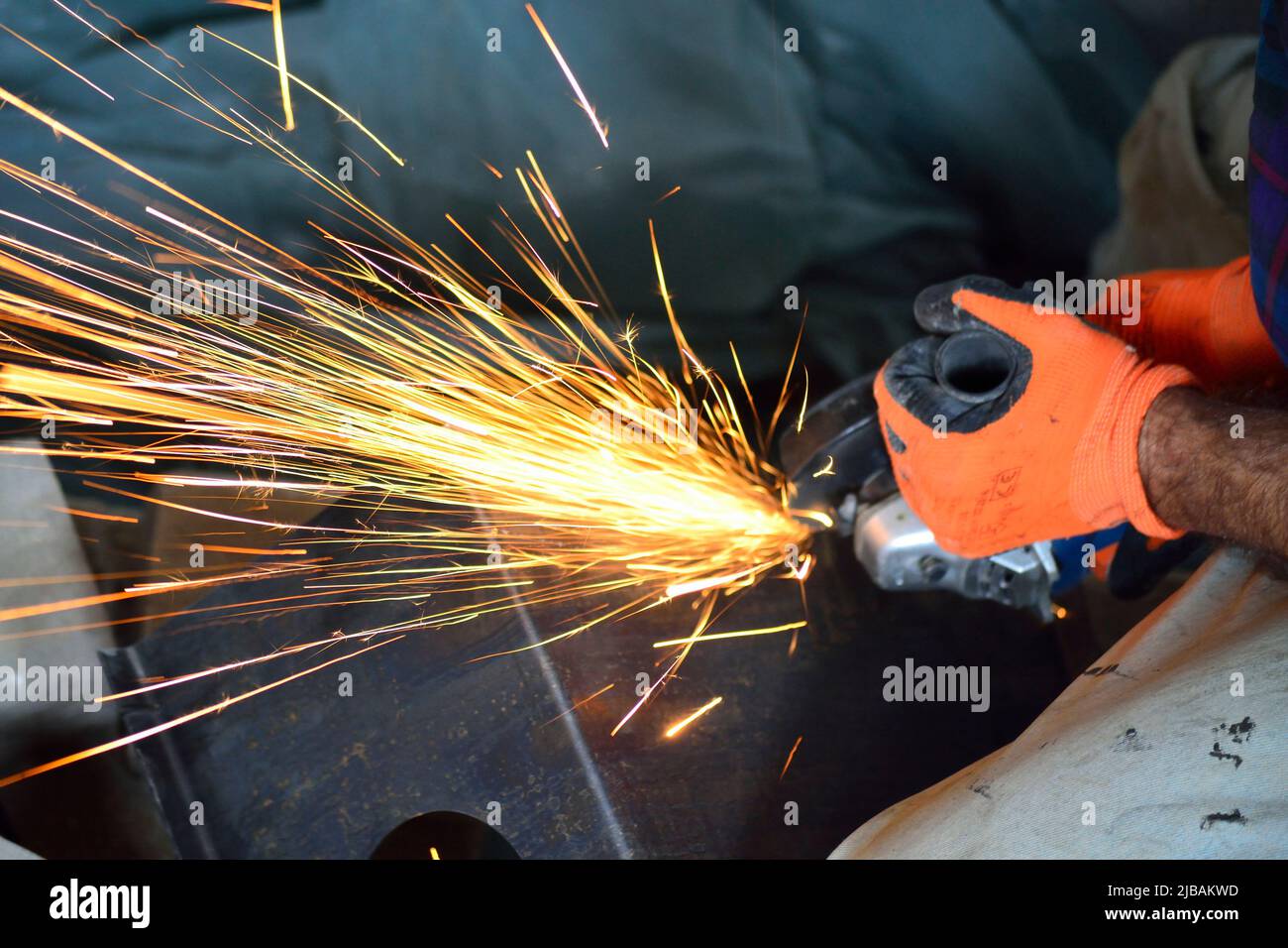 A man cuts metal using an angle grinder close-up. Many sparks Stock ...