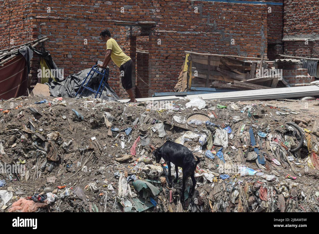 Delhi, India. 04th June, 2022. A man with a walker walks through a dump ...