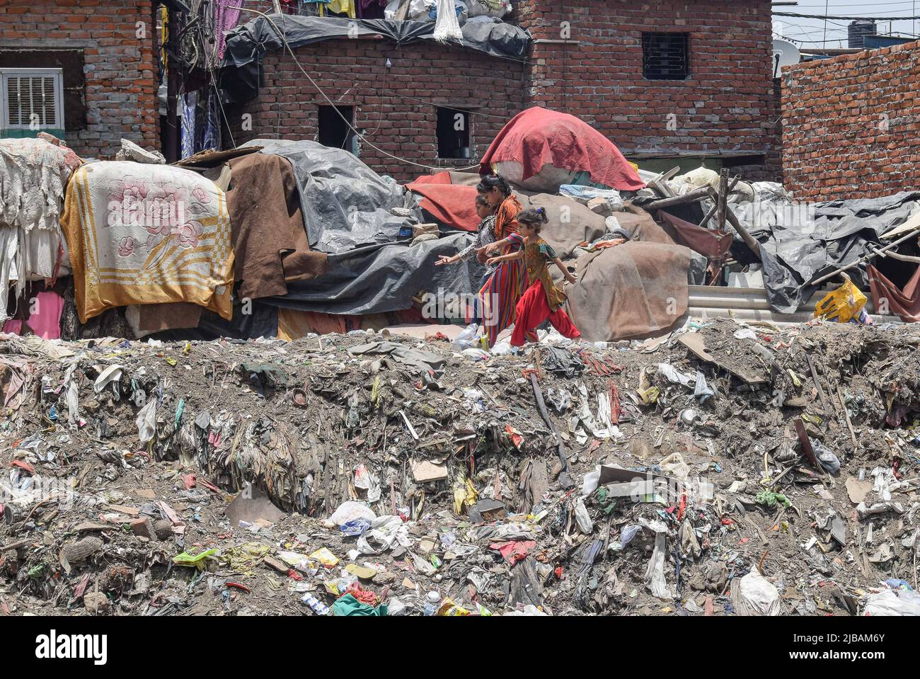 Delhi, India. 04th June, 2022. People walk through a dump full of ...