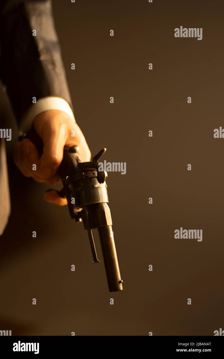 Male detective spy killer holding pistol gun in dramatic novel book ...