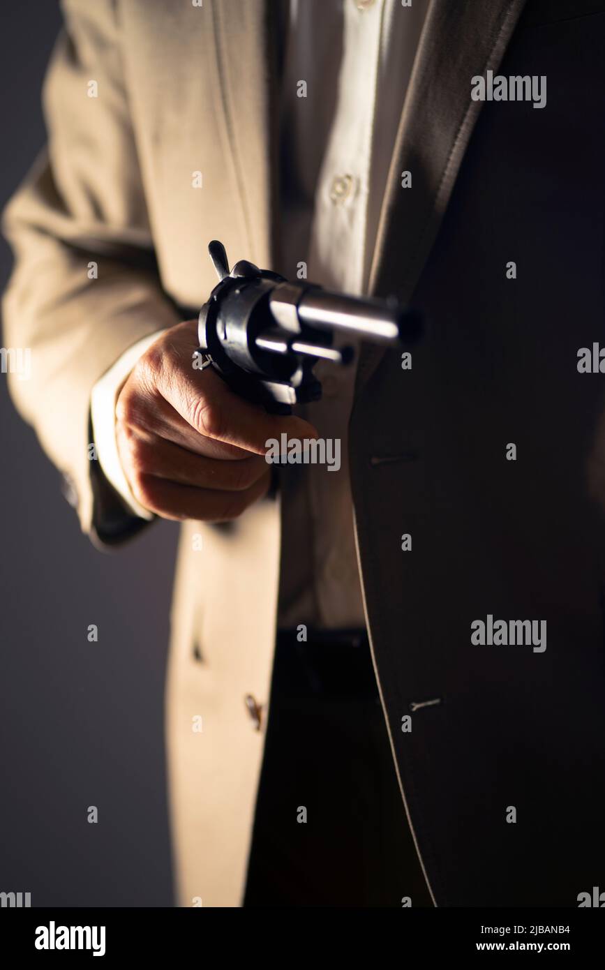 Male detective spy killer holding pistol gun in dramatic novel book ...