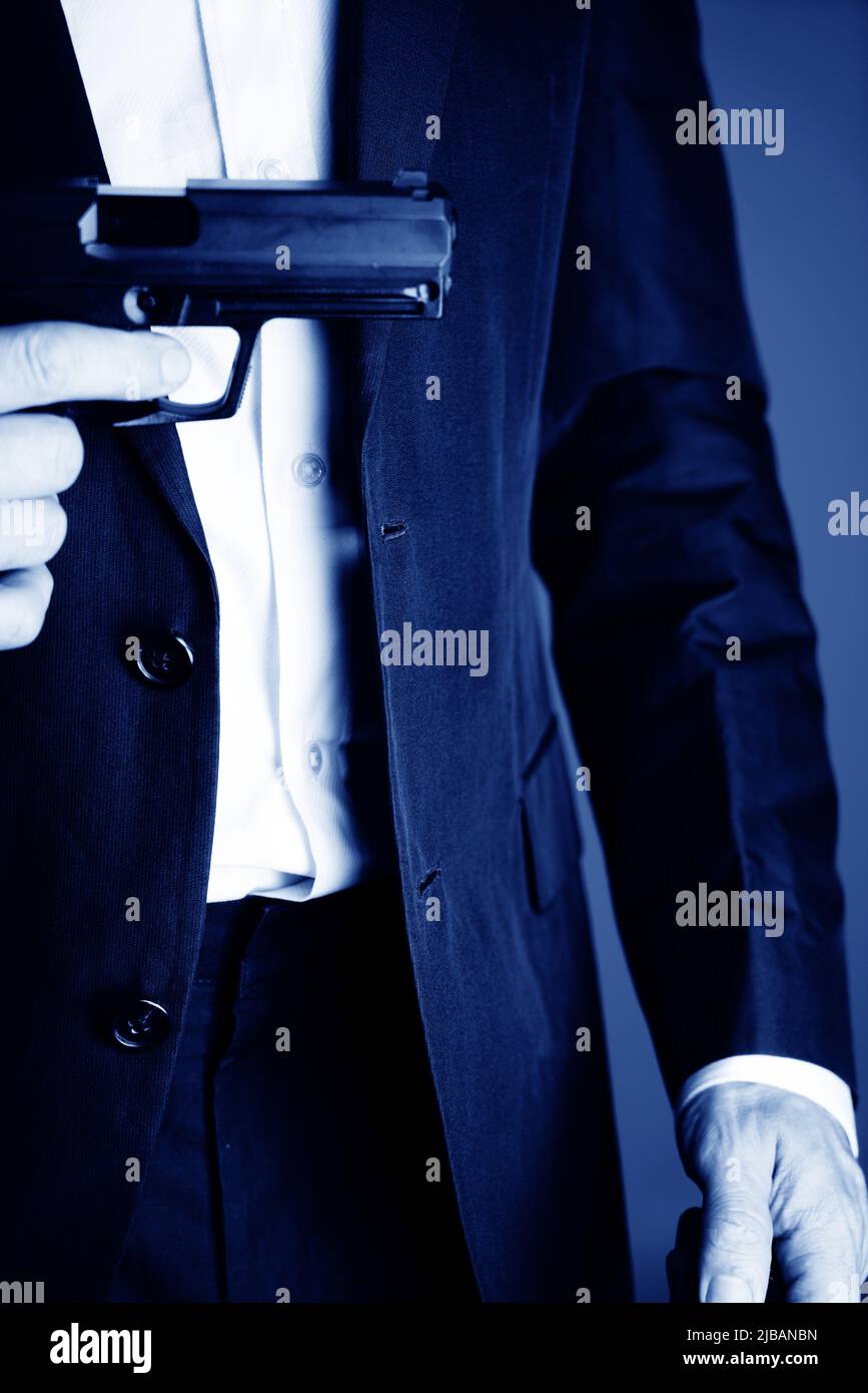 Retro secret agent with pistol revolver gun in hand in vintage crime ...