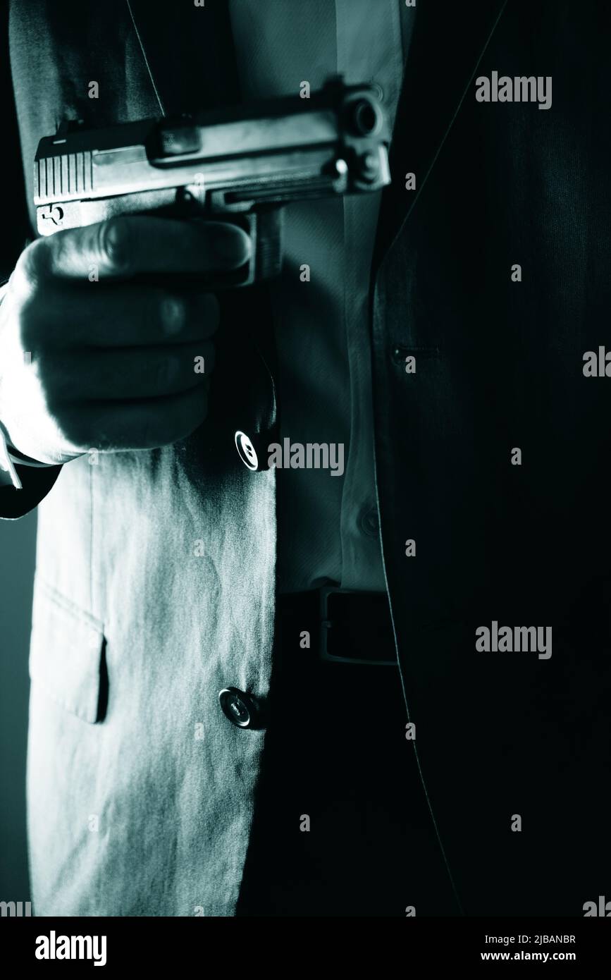 Retro secret agent with pistol revolver gun in hand in vintage crime ...