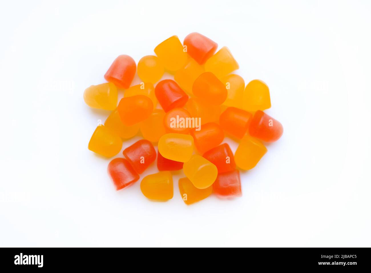 Close-up texture of orange and yellow multivitamin gummies in the form ...