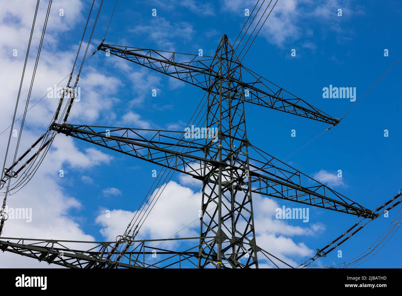 Electrical net of poles on a panorama of blue sky and green meadow ...