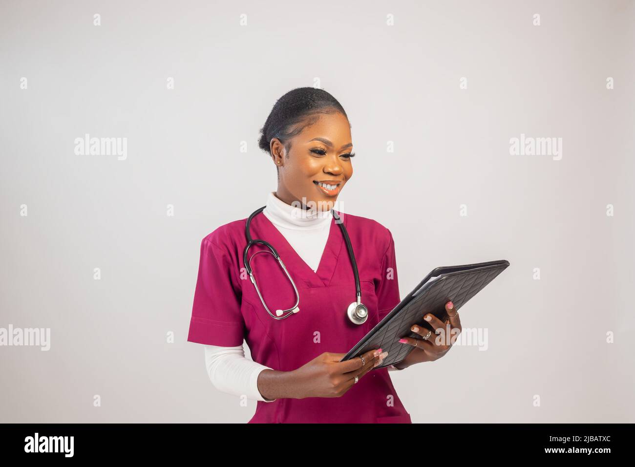 Smiling nurse holding a file while standing Stock Photo - Alamy