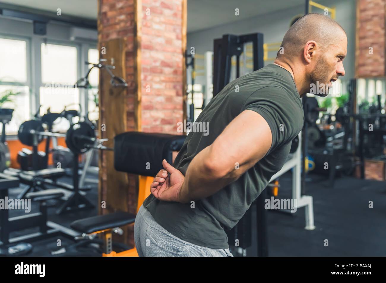 Muscular man having a back pain , view from a side, sport concept. High ...
