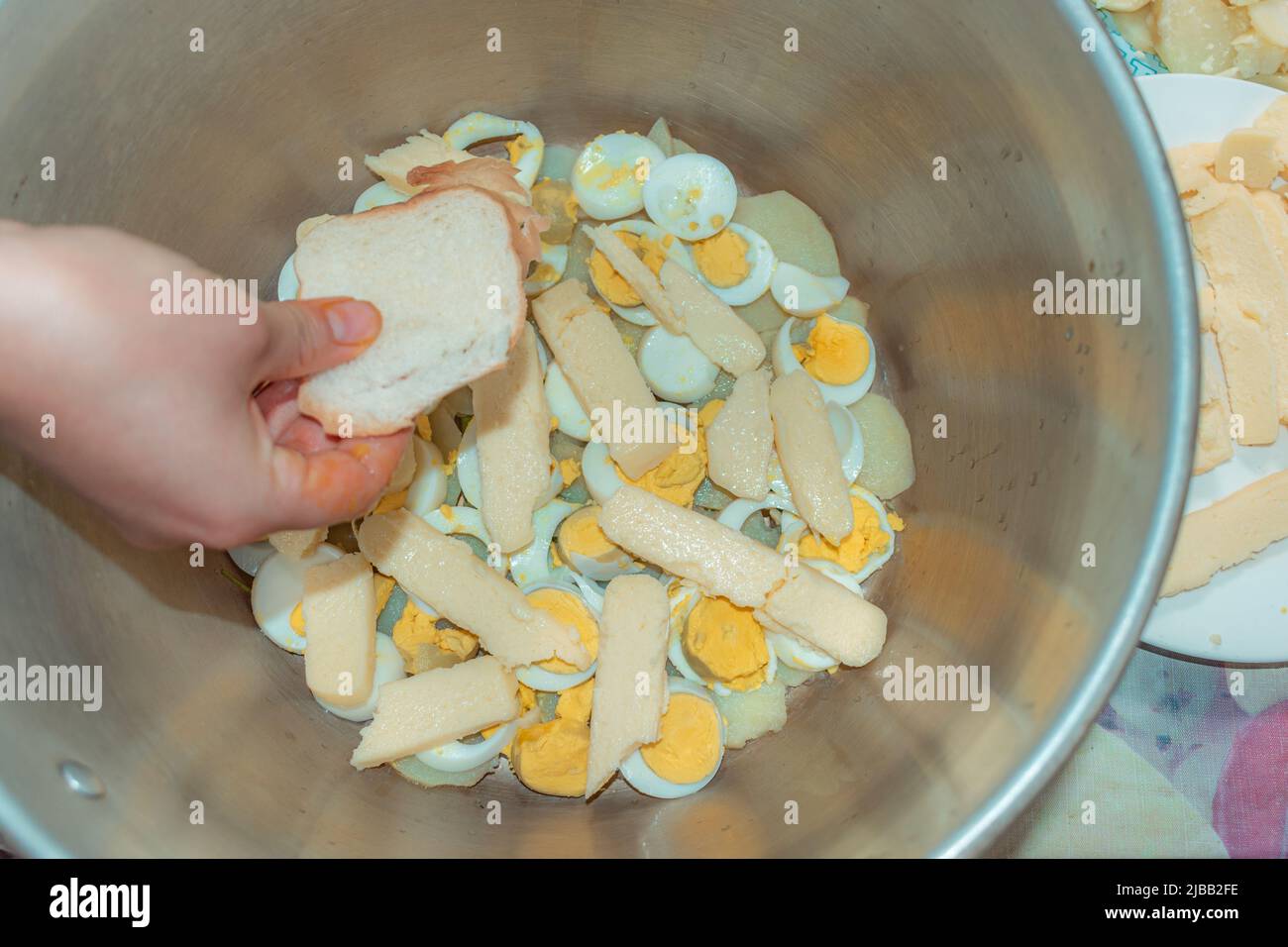 man's hand preparing typical colombian bread soup during holy week ...