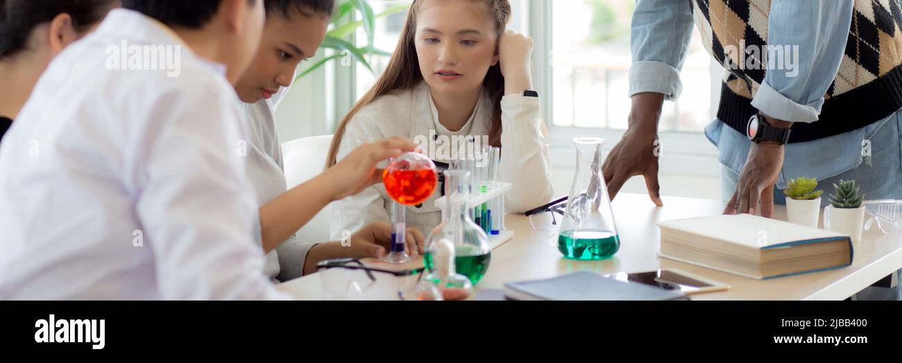 Young teacher teaching group student about science and test chemical ...