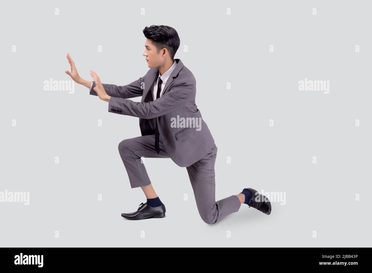 Young asian business man pushing something isolated on white background ...