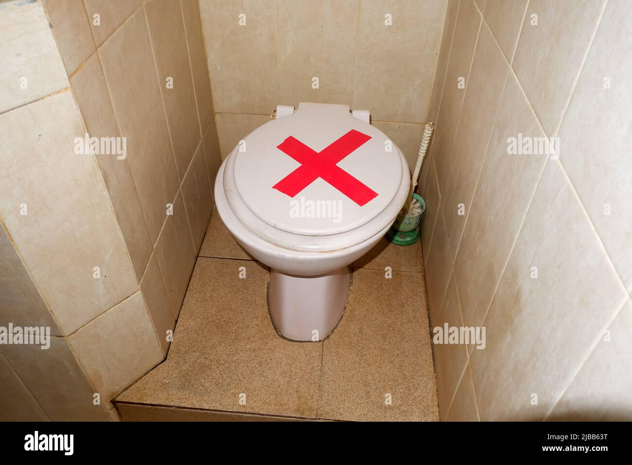 a toilet with a cross sign indicates a broken toilet cannot be used ...