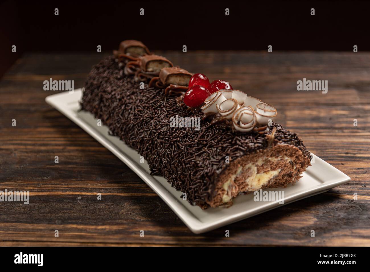 A delicious Swiss roll on woodden background. Sponge roll cake ...