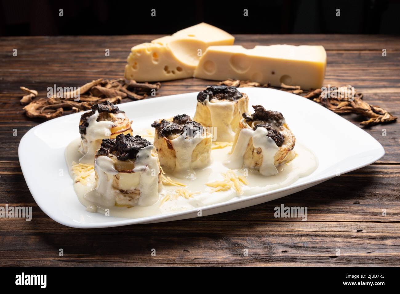 Homemade rondelli with four cheese and mushuroom sauce in white plate ...