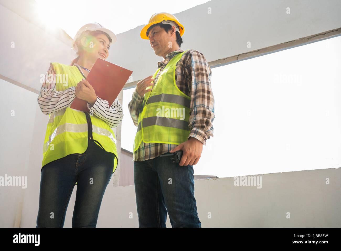 Asian engineer or Young Female Architect put on a helmet for safety and ...