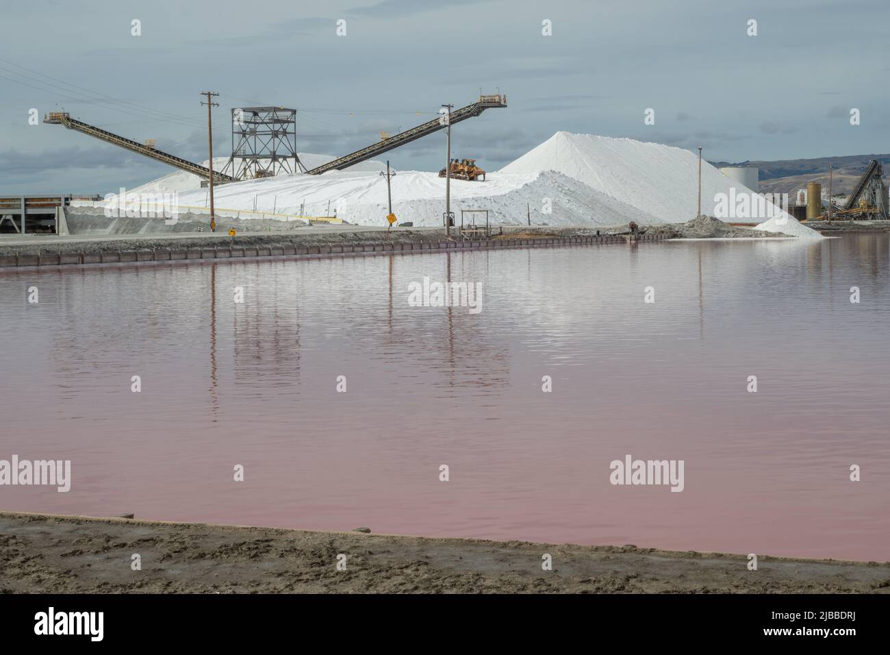 Sea salt production and piles of salt crystals overlooking ponds Stock ...