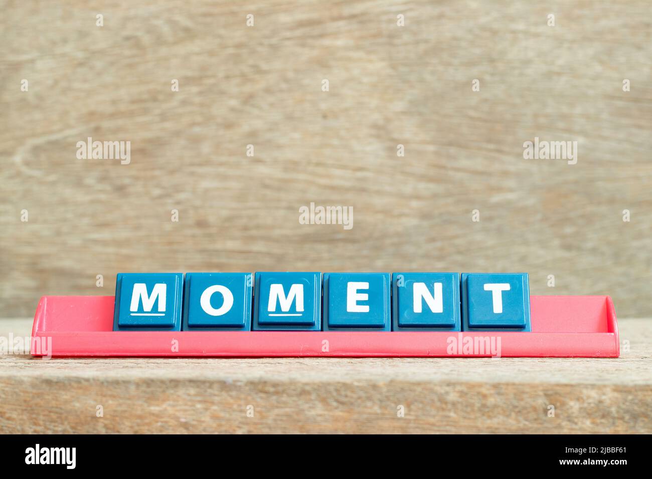 Tile alphabet letter with word moment in red color rack on wood ...
