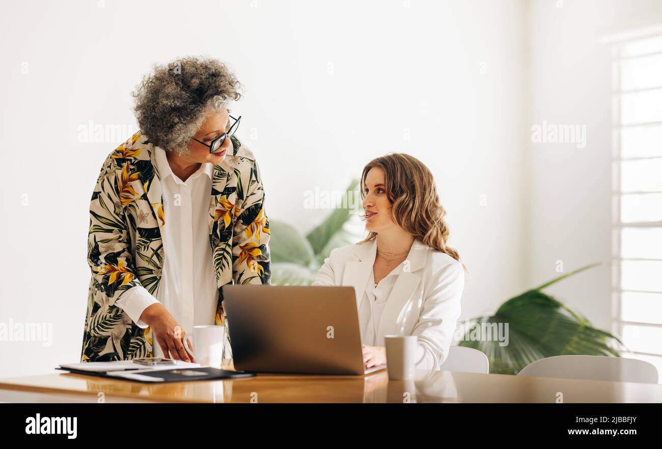 Female manager having a discussion with her colleague in a meeting room ...