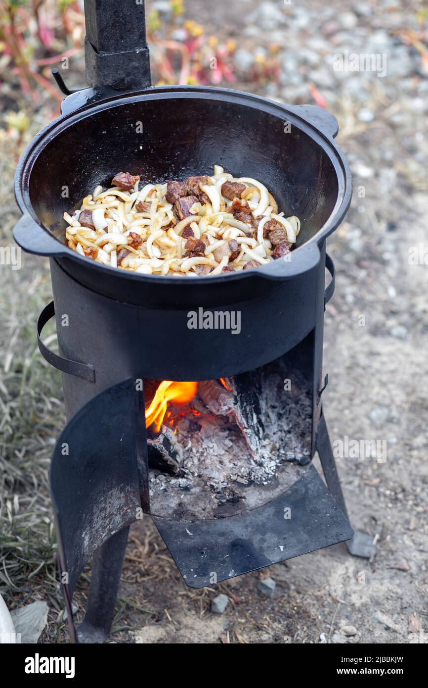 Cooking food or pilaf in a cauldron on fire. Cooking in cauldron on ...