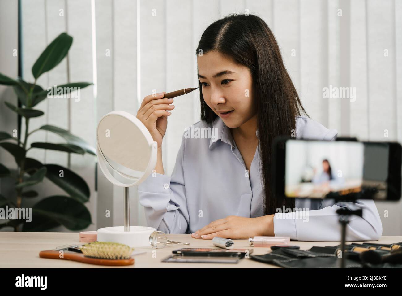 Young asian woman vlogging about cosmetics skin care items products on ...