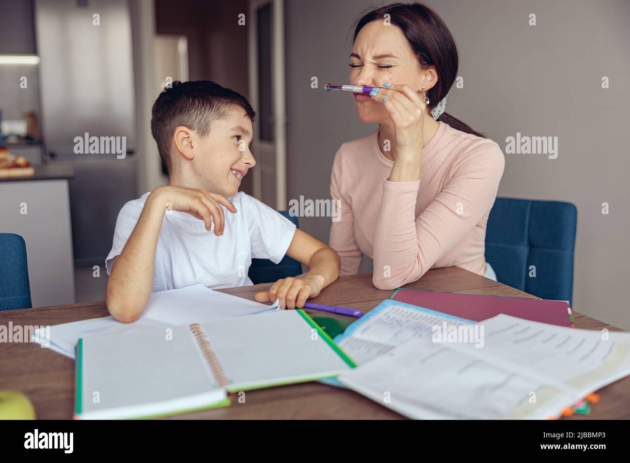Pretty young mother having fun, making laugh her small son, mocking ...