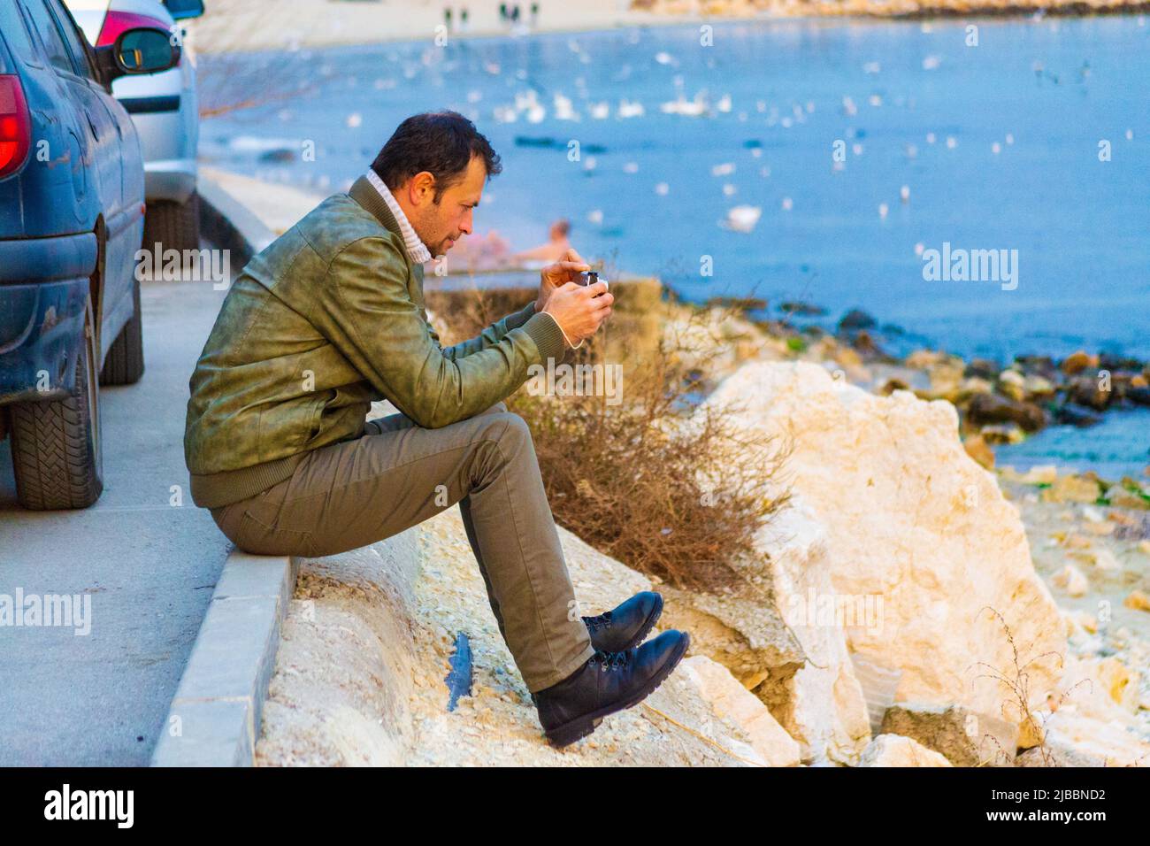 Handsome young man enjoying the view of winter sea at Varna beach ...