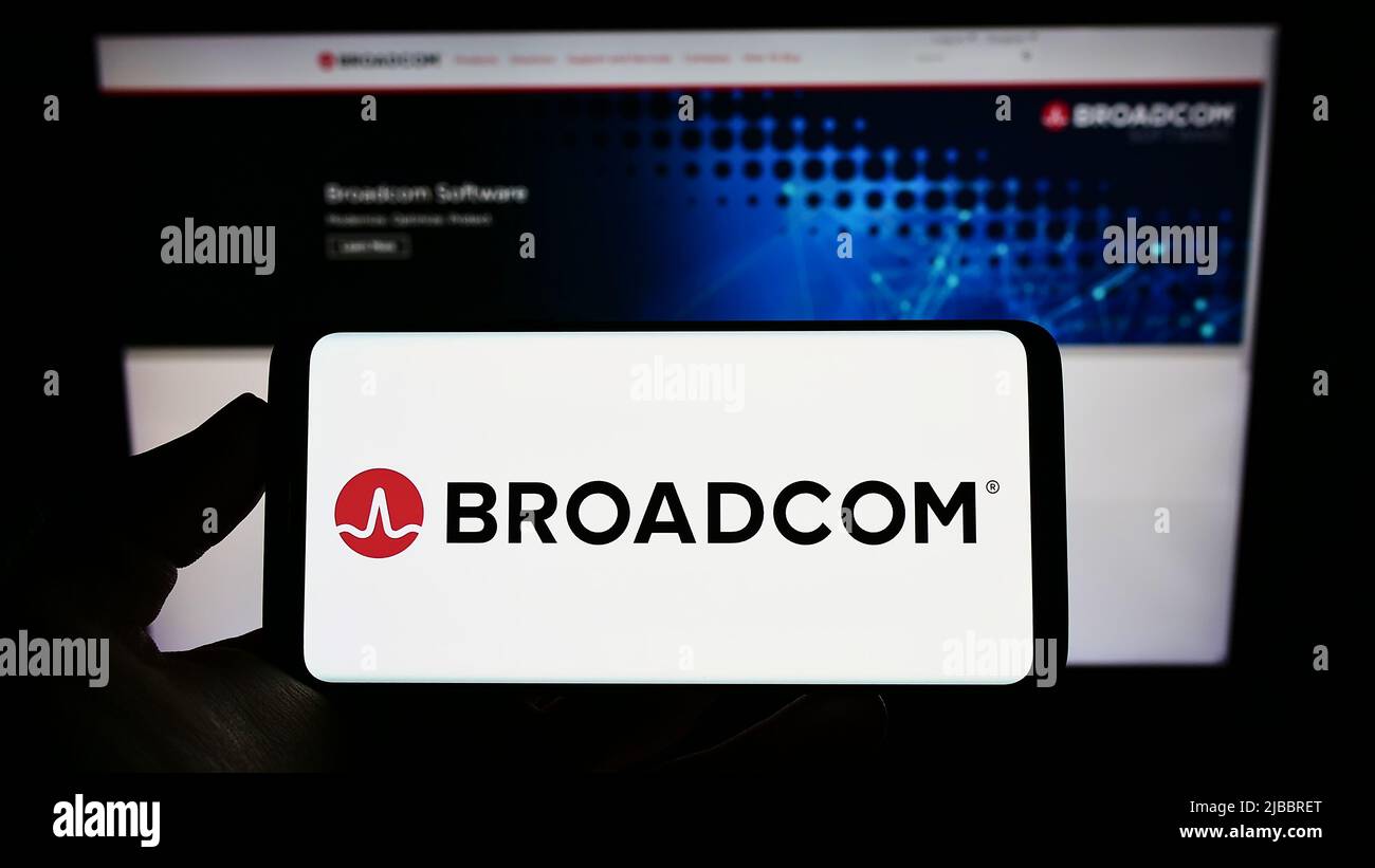 Person holding cellphone with logo of US semiconductor company Broadcom ...