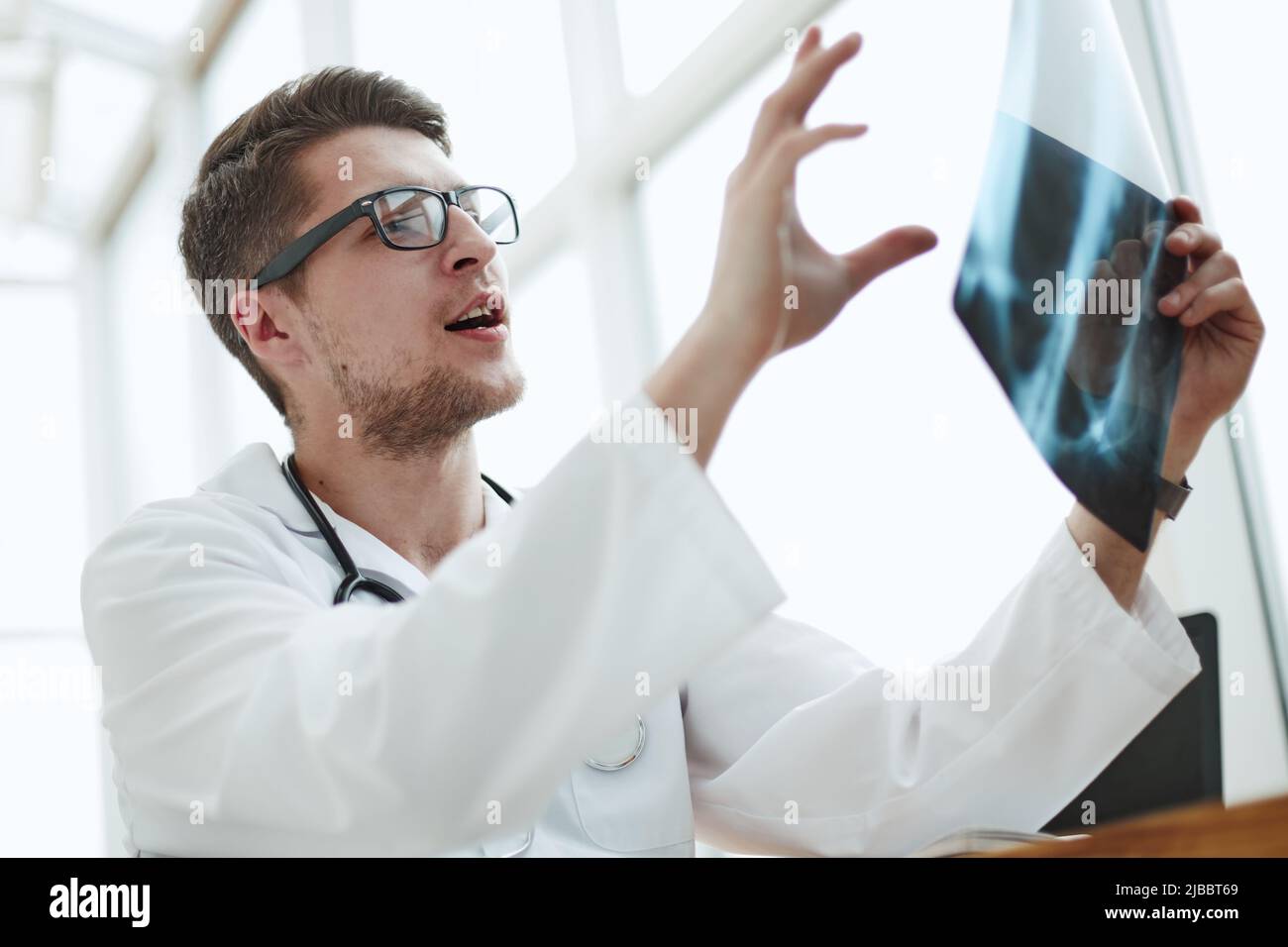 Male doctor radiologist examines x-rays in a medical office Stock Photo ...