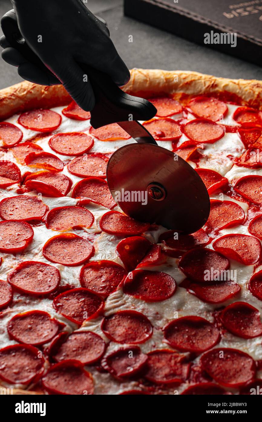 Closeup on cutting fresh pepperoni pizza Stock Photo - Alamy
