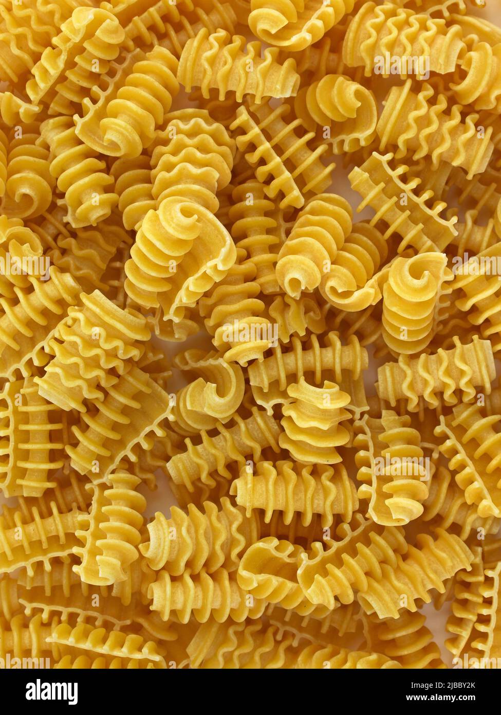 Dry curly pasta close-up. Pasta made of durum wheat top view. Yellow ...