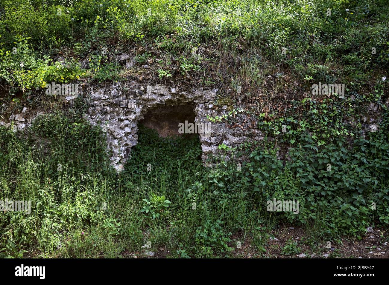 Hole in a stone wall shaped as a votive chapel Stock Photo - Alamy