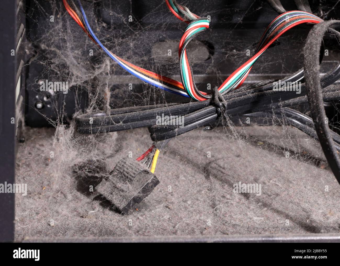The wires in the computer system unit are covered with dust. A layer of ...