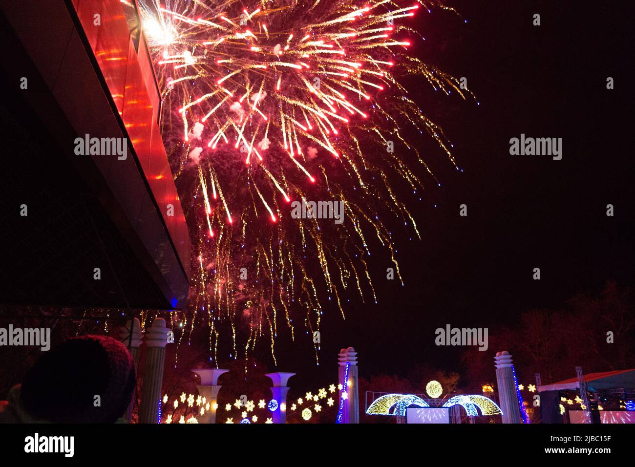 Flashes of bright festive fireworks on the black sky background over ...