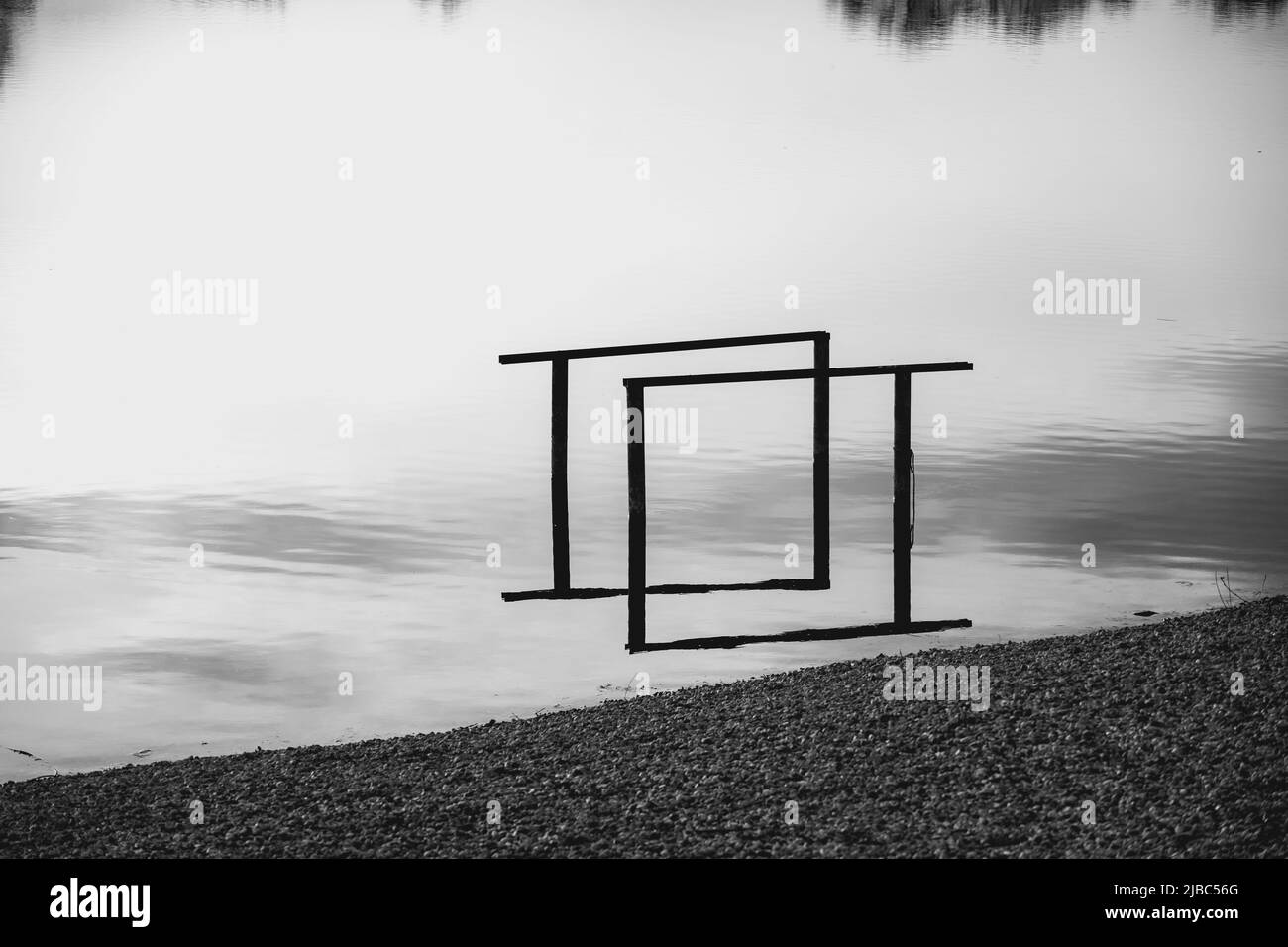 Steel structures standing in the shallow water, reflected in the ...