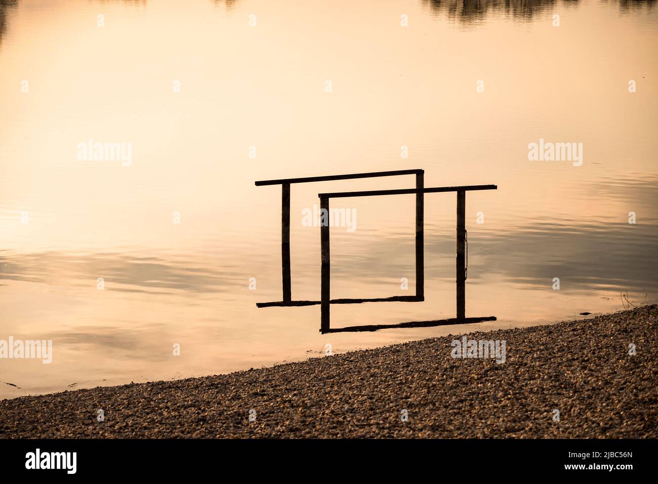 Steel structures standing in the shallow water, reflected in the ...