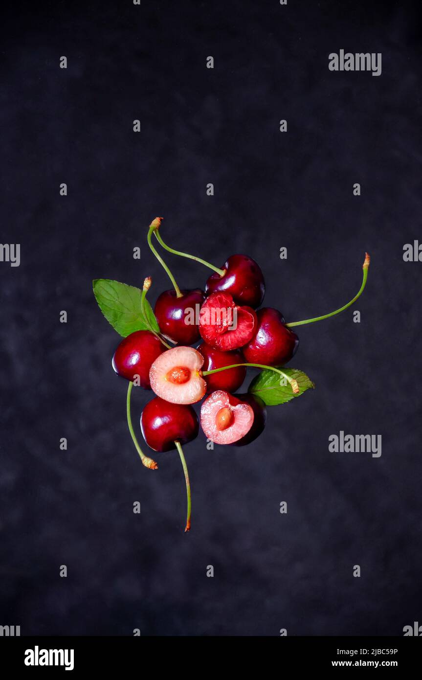 Close up Composition of Cherries Flying in the air on Dark Background ...