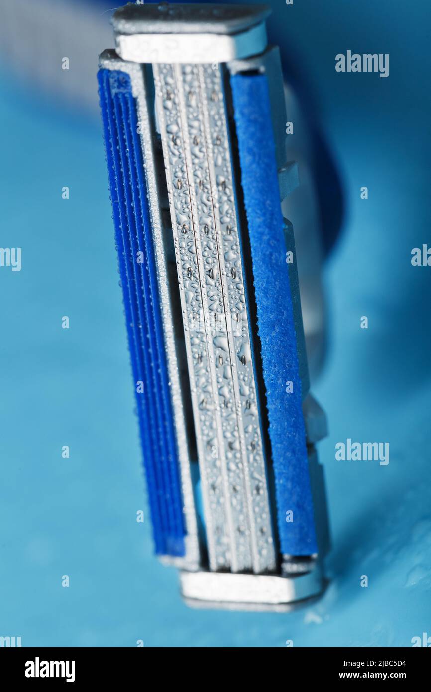 Razor blades on a blue background with drops of icy water close-up free ...