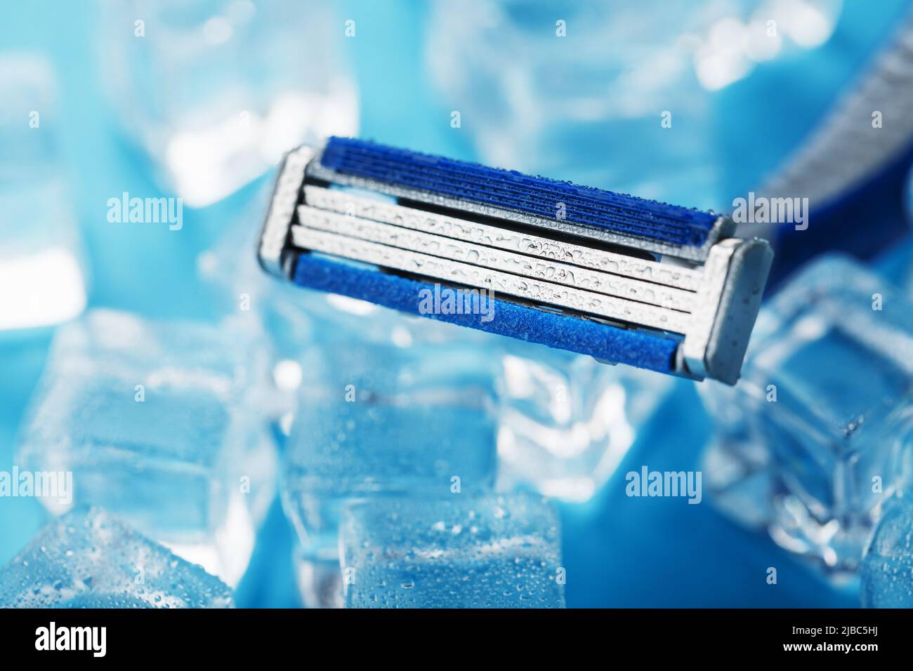 Shaving machine on a blue background with ice cubes. The concept of ...