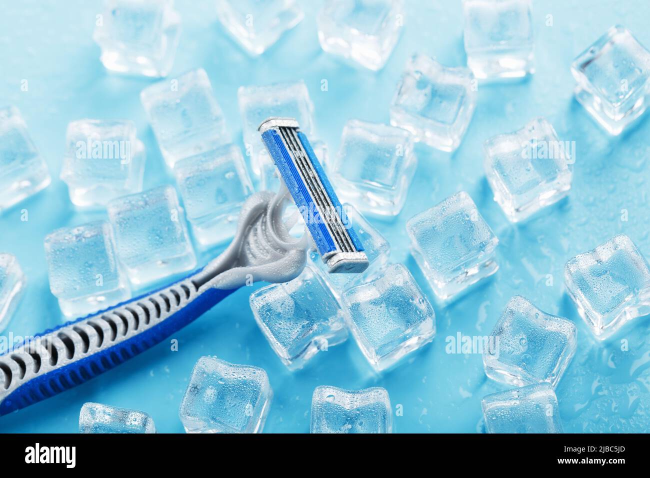 Shaving machine on a blue background with ice cubes. The concept of ...