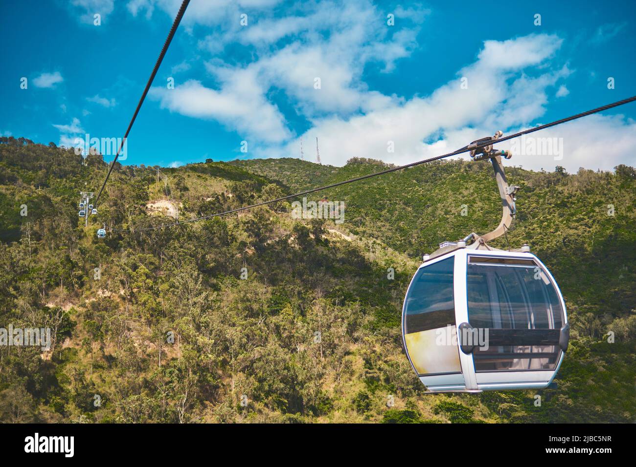 Modular cabins cable car against the bright sky, clouds ans mountains ...