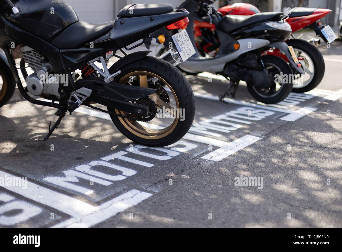 Motorbikes parked on a parking lot outside. Sign on the road Stock ...
