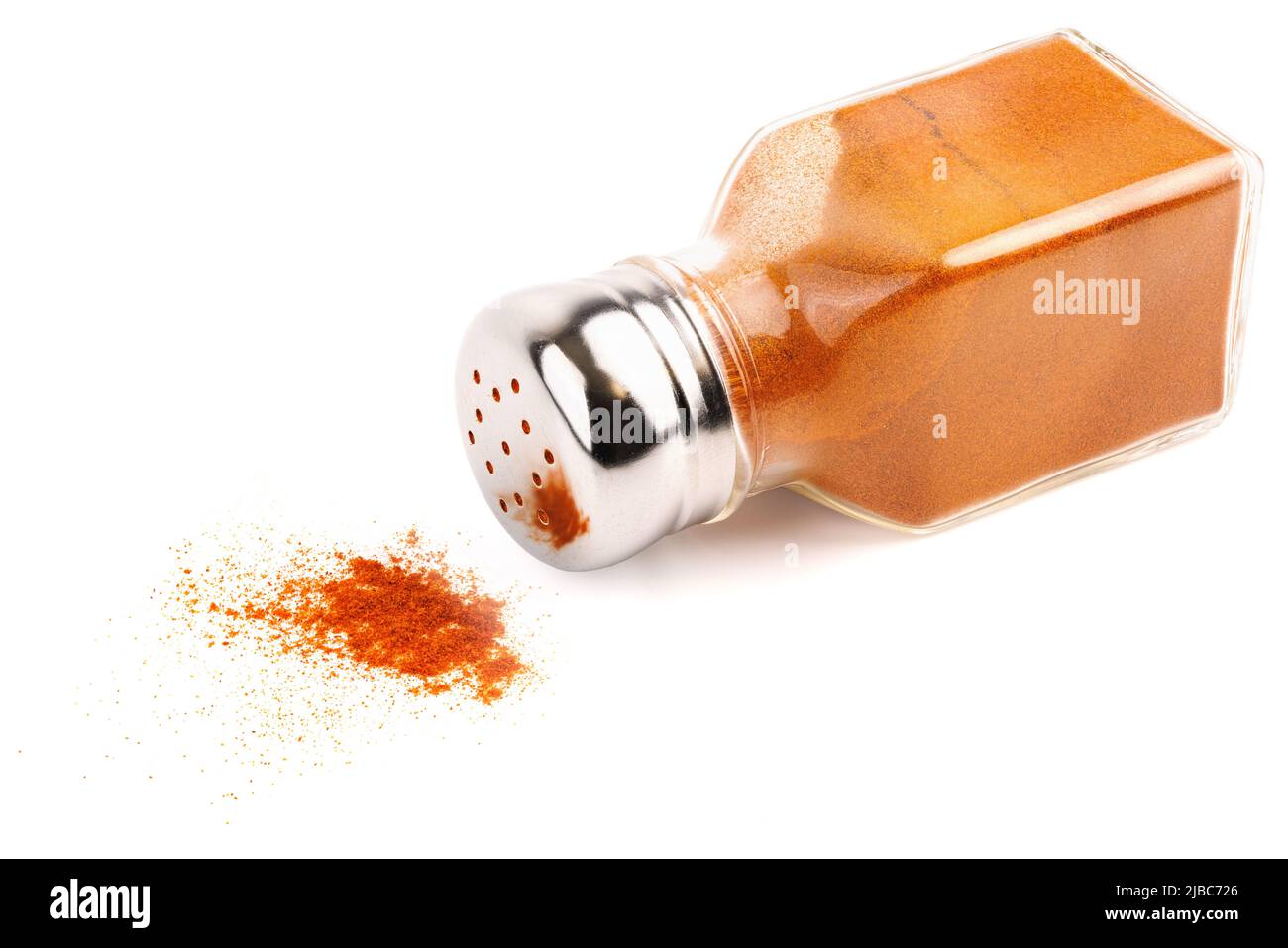 glass pepper pot with ground red pepper dropped on its side isolated on ...