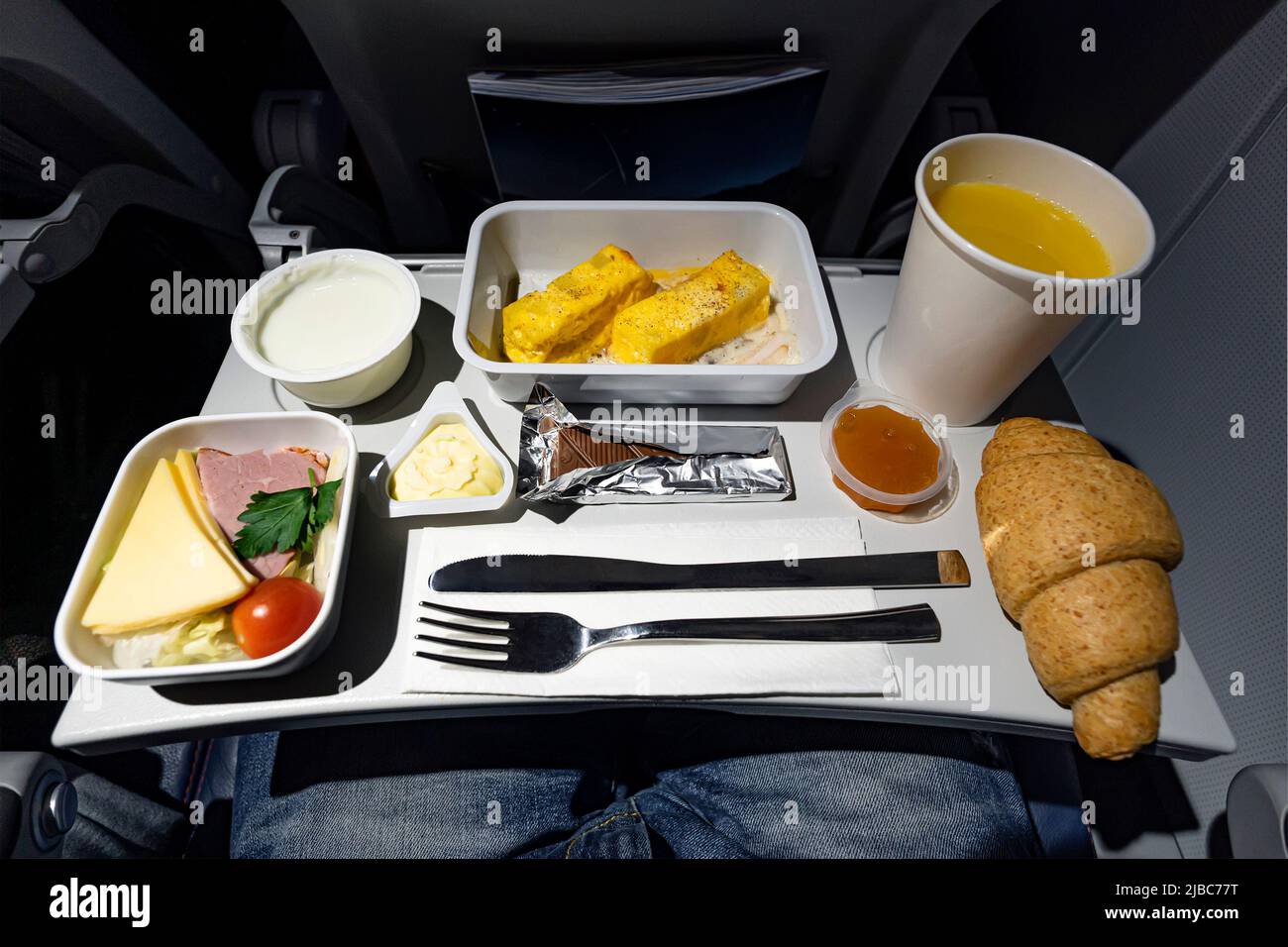 A variety of food on the folding table on the plane. Late dinner during ...
