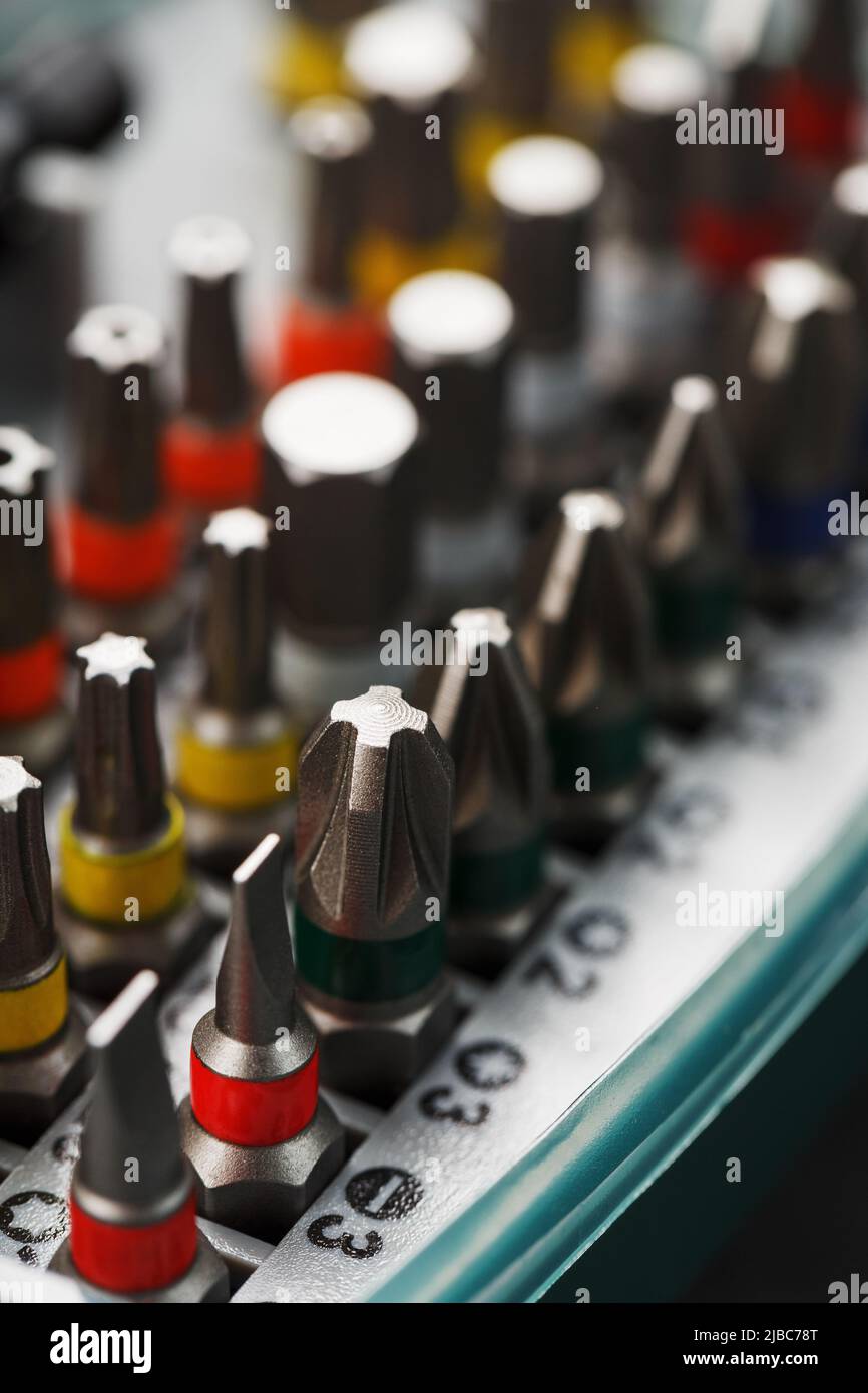 A set of metal power bits in a box on a gray background, for repair and ...