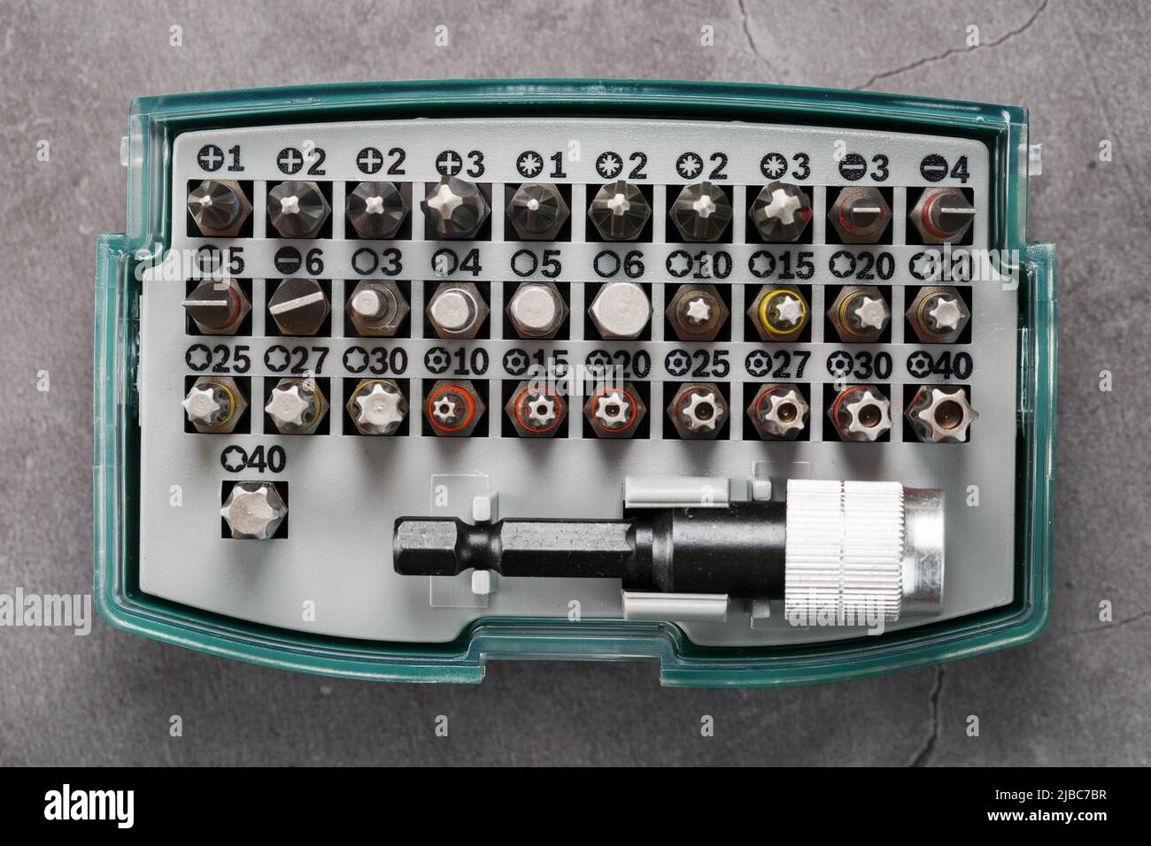 A set of metal power bits in a box on a gray background, for repair and ...