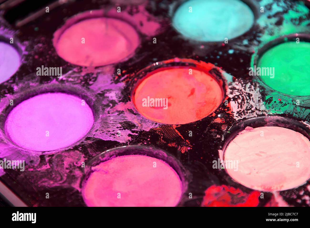 Dirty palette with dry paints of red, pink, purple colors. Artists ...