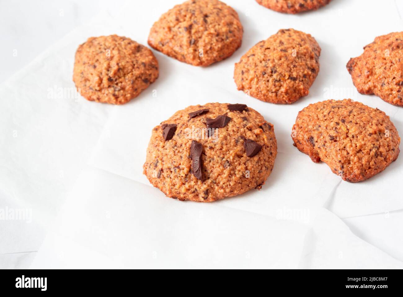 Homemade oat cookies with chocolate over white background. Rustic snack ...
