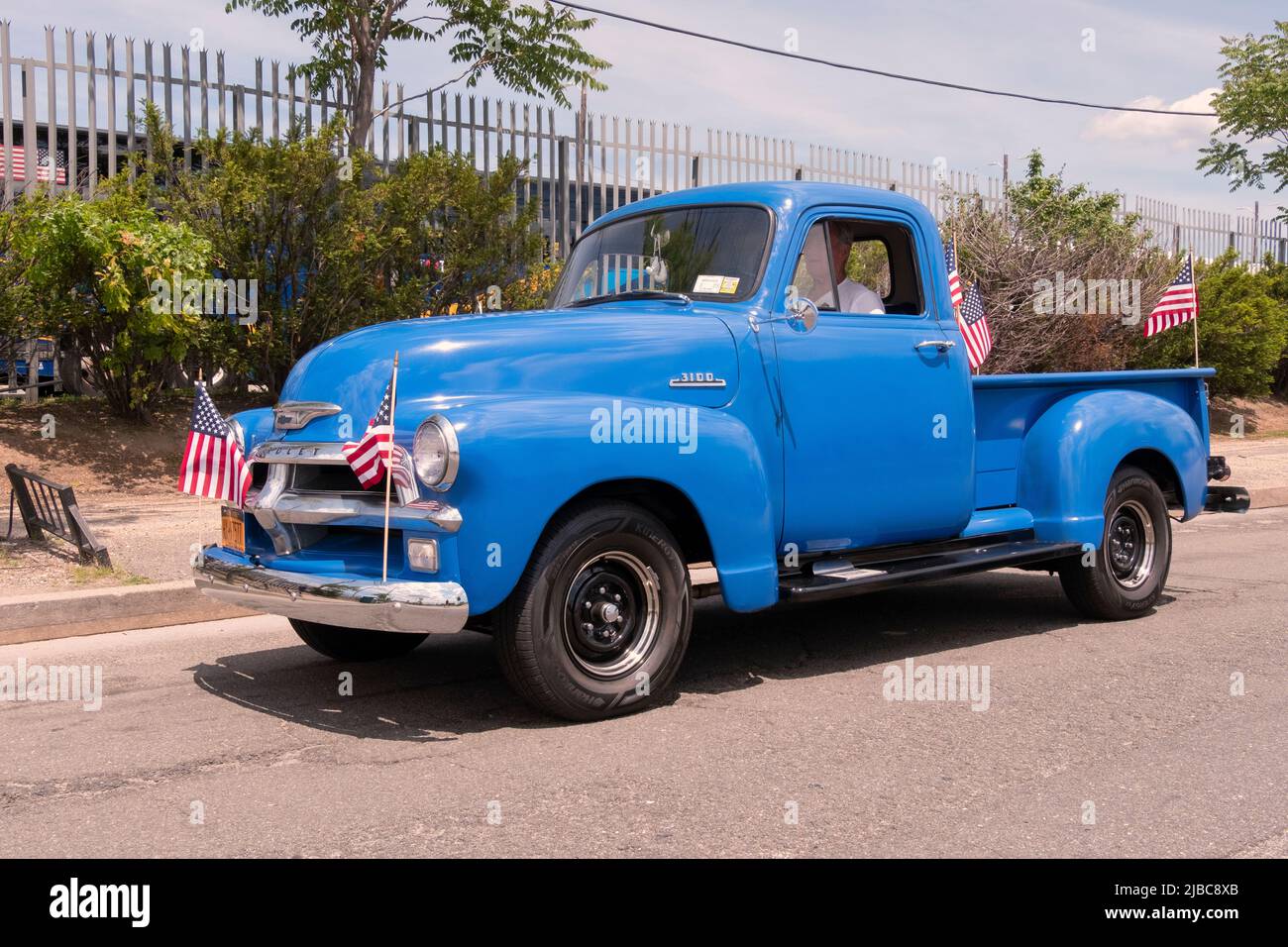 A restored 1954 Chevrolet model 3100 adorned with 4 American flags ...