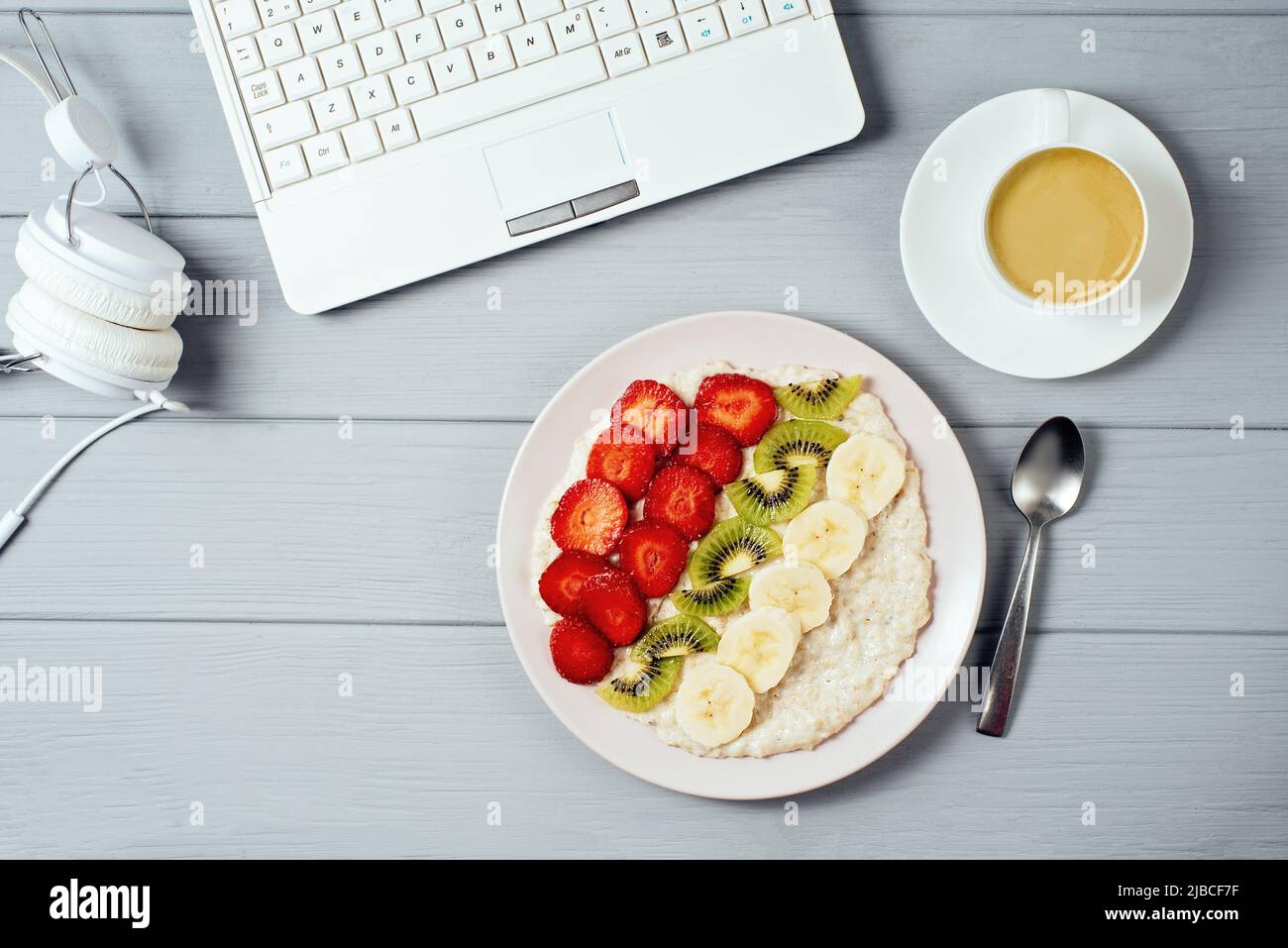 Healthy breakfast oatmeal with bananas, kiwi and strawberry in front of ...