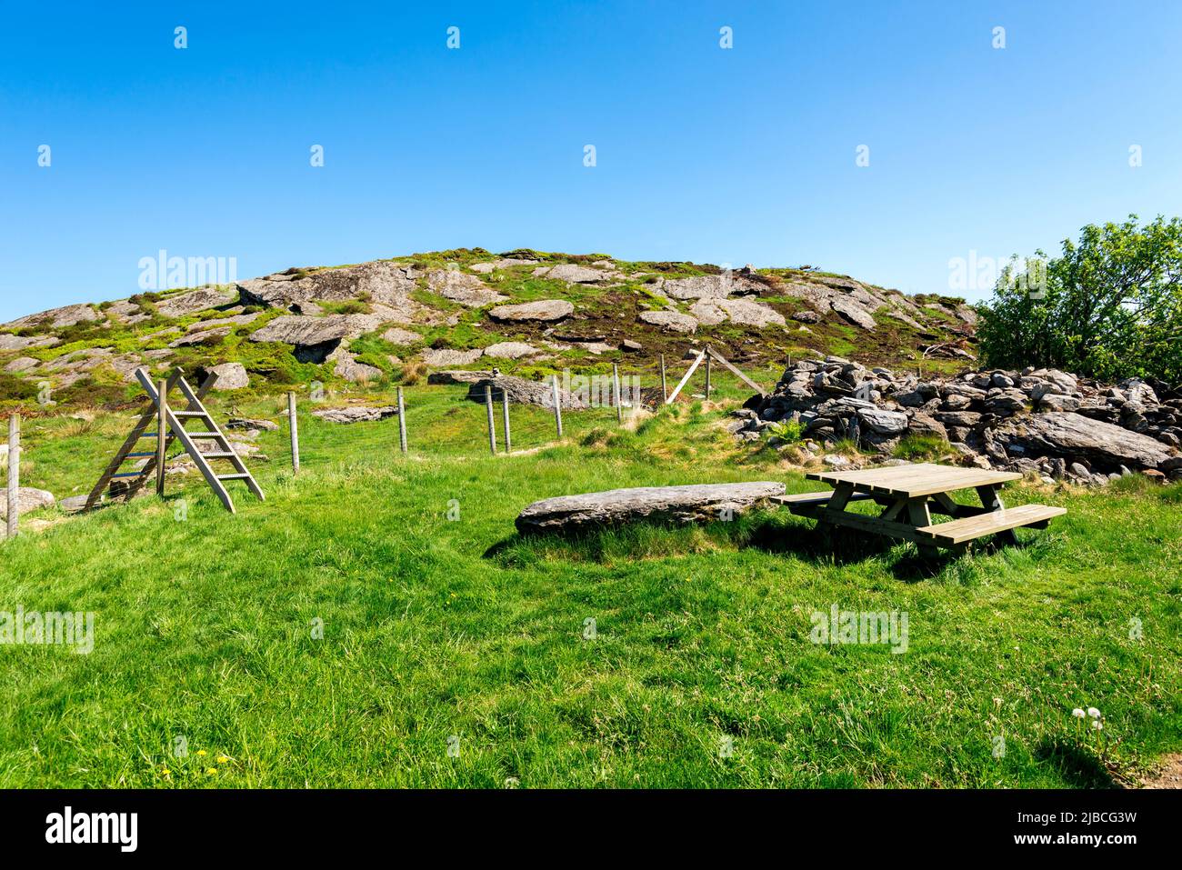 A picnic table and a ladder over the fence to hike the hill for ...